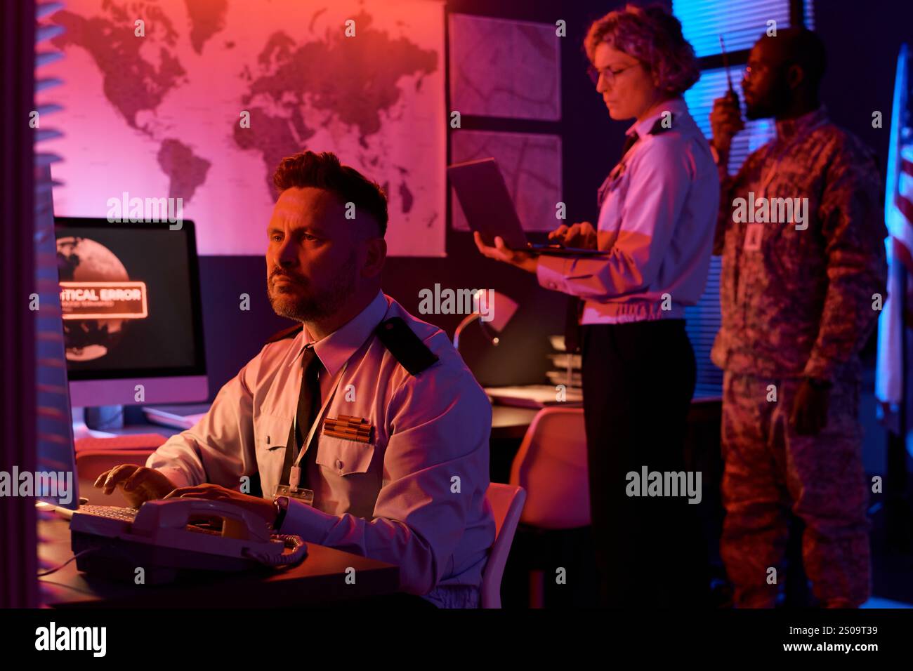 Serious mature male officer sitting in front of desktop computer and ...