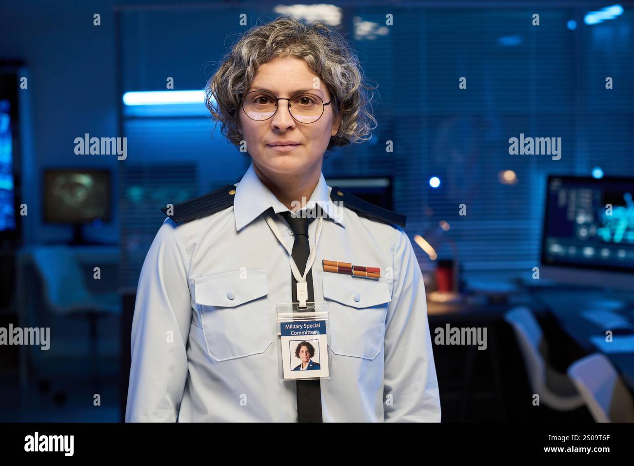 Serious mature grey haired woman in eyeglasses and uniform looking at ...