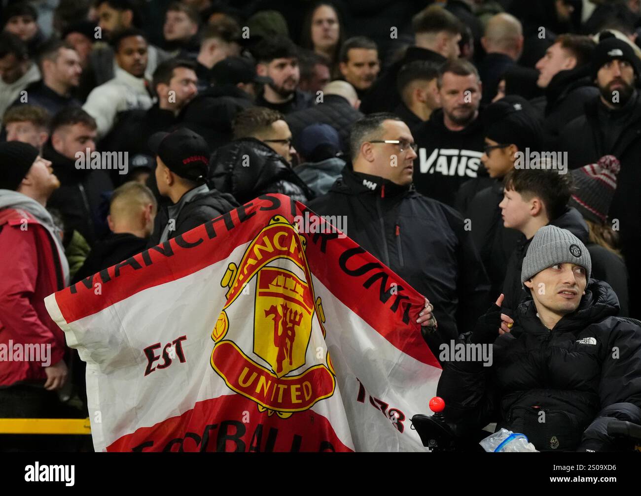 A Manchester United fans folds up her flag after her side conceded a ...