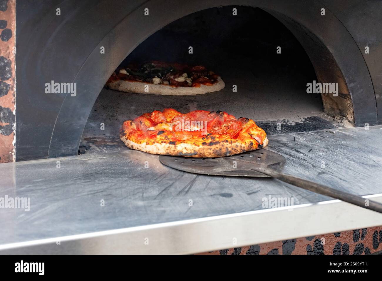 Savoring the moment as a perfectly baked pizza emerges from a ...
