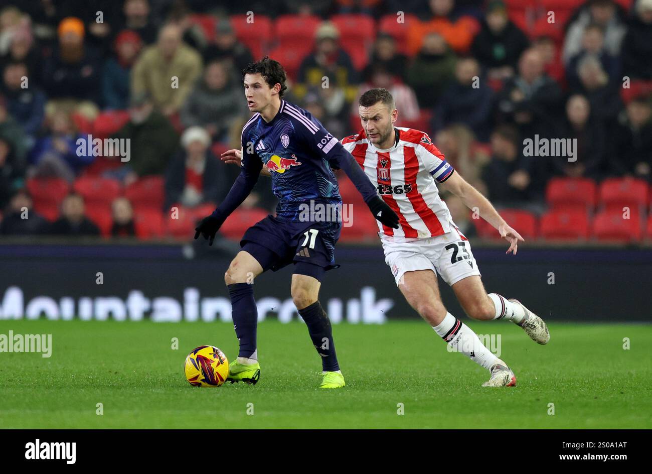 Leeds United's Brenden Aaronson (left) and Stoke City's Ben Gibson ...