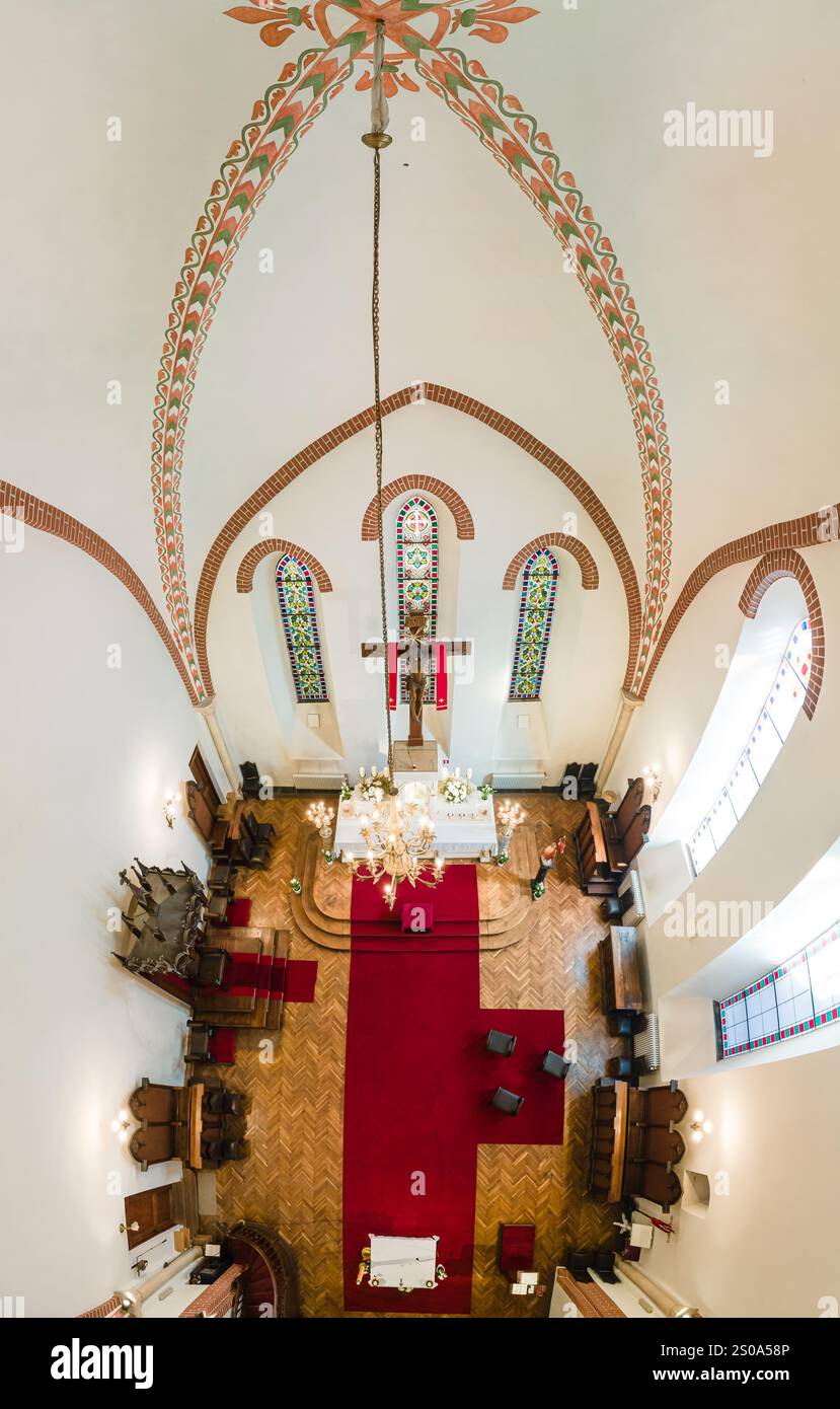 The image shows an aerial view of a cathedral's interior, featuring red ...
