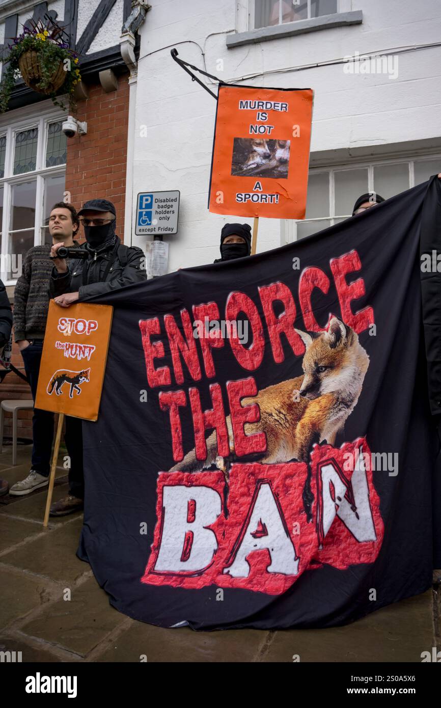 Leominster, UK. 26th Dec, 2024. Anti hunt protestors hold a banner and ...