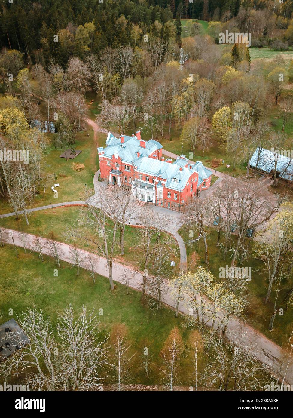 An aerial perspective captures a large red brick mansion with a blue ...