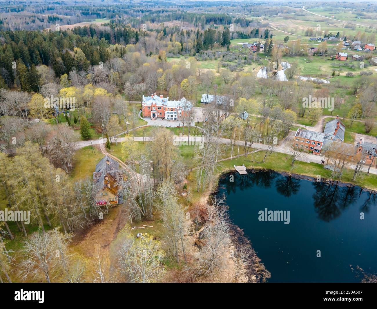 An aerial perspective captures a red brick mansion amidst trees, with a ...