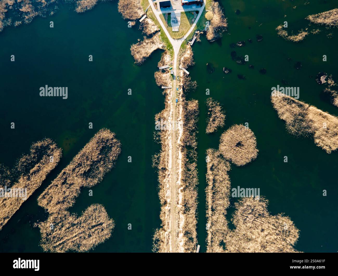 An aerial perspective shows a narrow path through green water, bordered ...