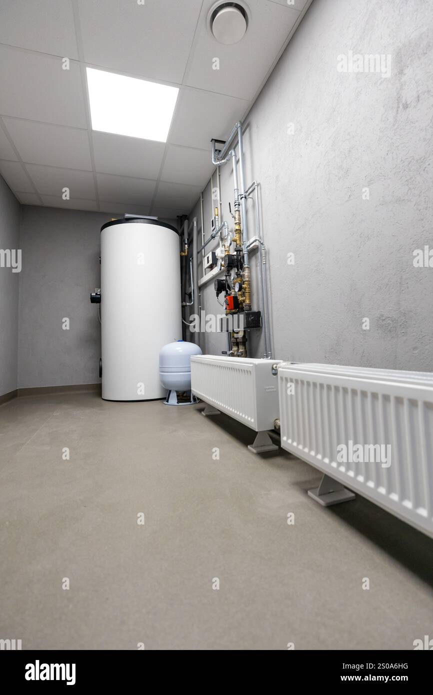 A well lit utility room features a white cylindrical water heater, blue ...