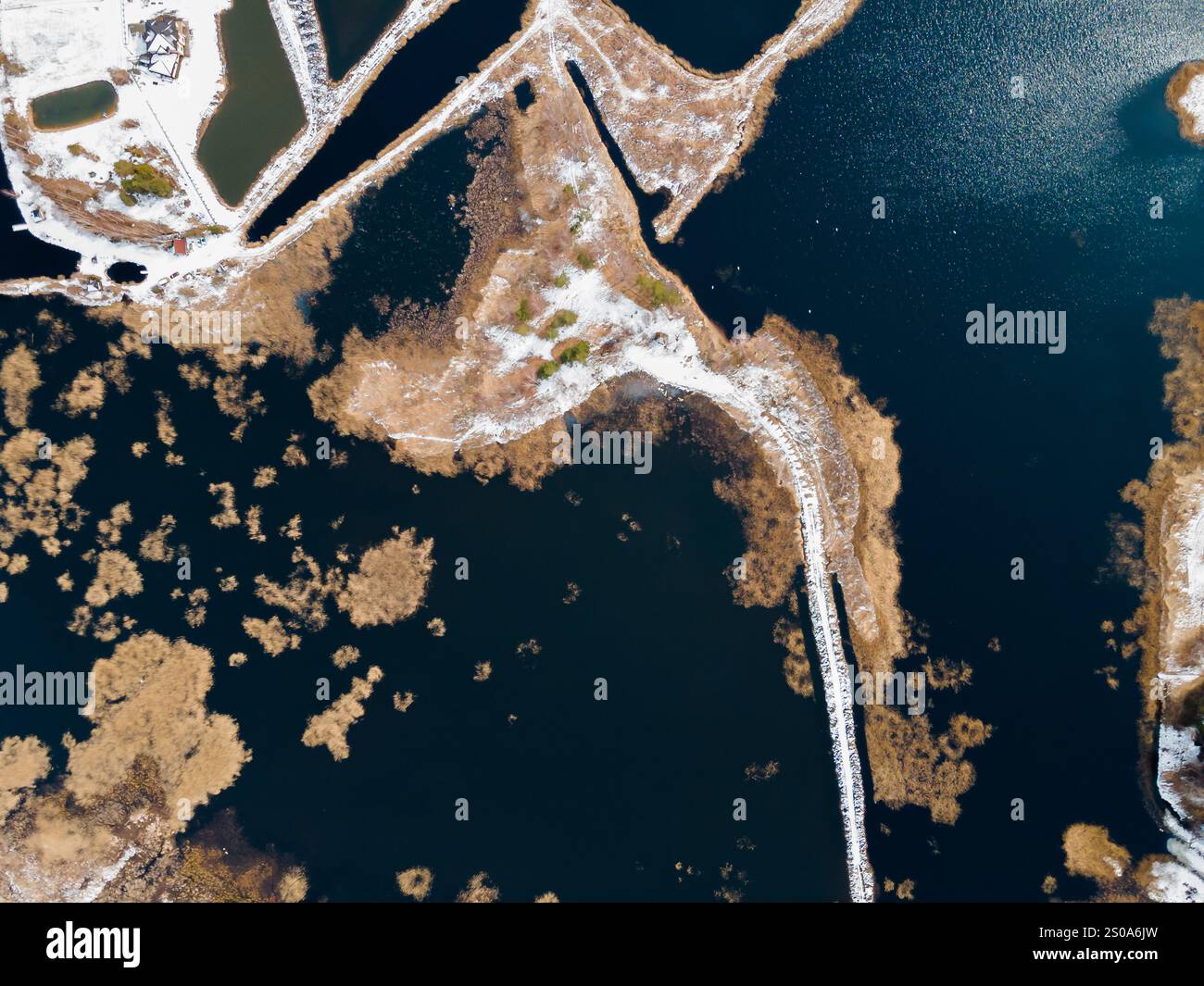 An aerial perspective reveals a network of ponds and channels, bordered ...