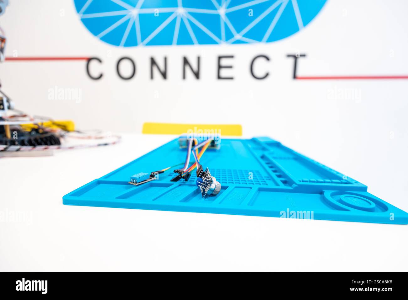 A blue electronics work mat holds small components and wires. A ...