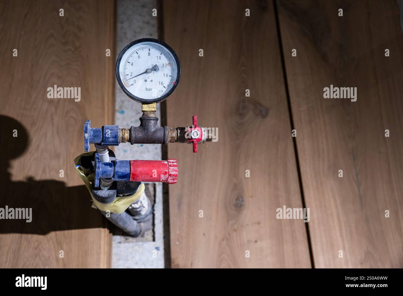A pressure gauge displays measurements in bars, attached to pipes with ...