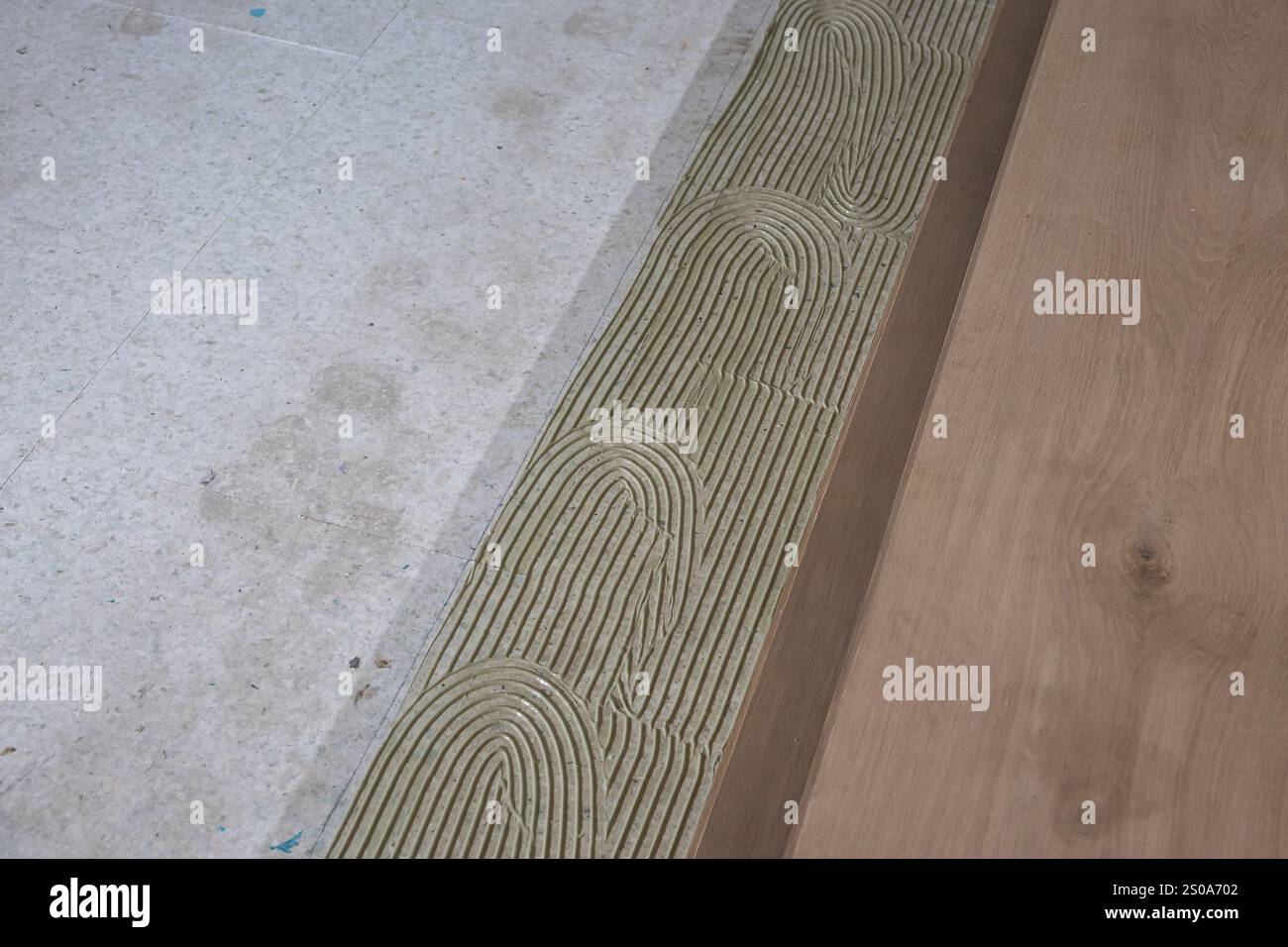 Detailed view of adhesive applied in wavy pattern on subfloor ...