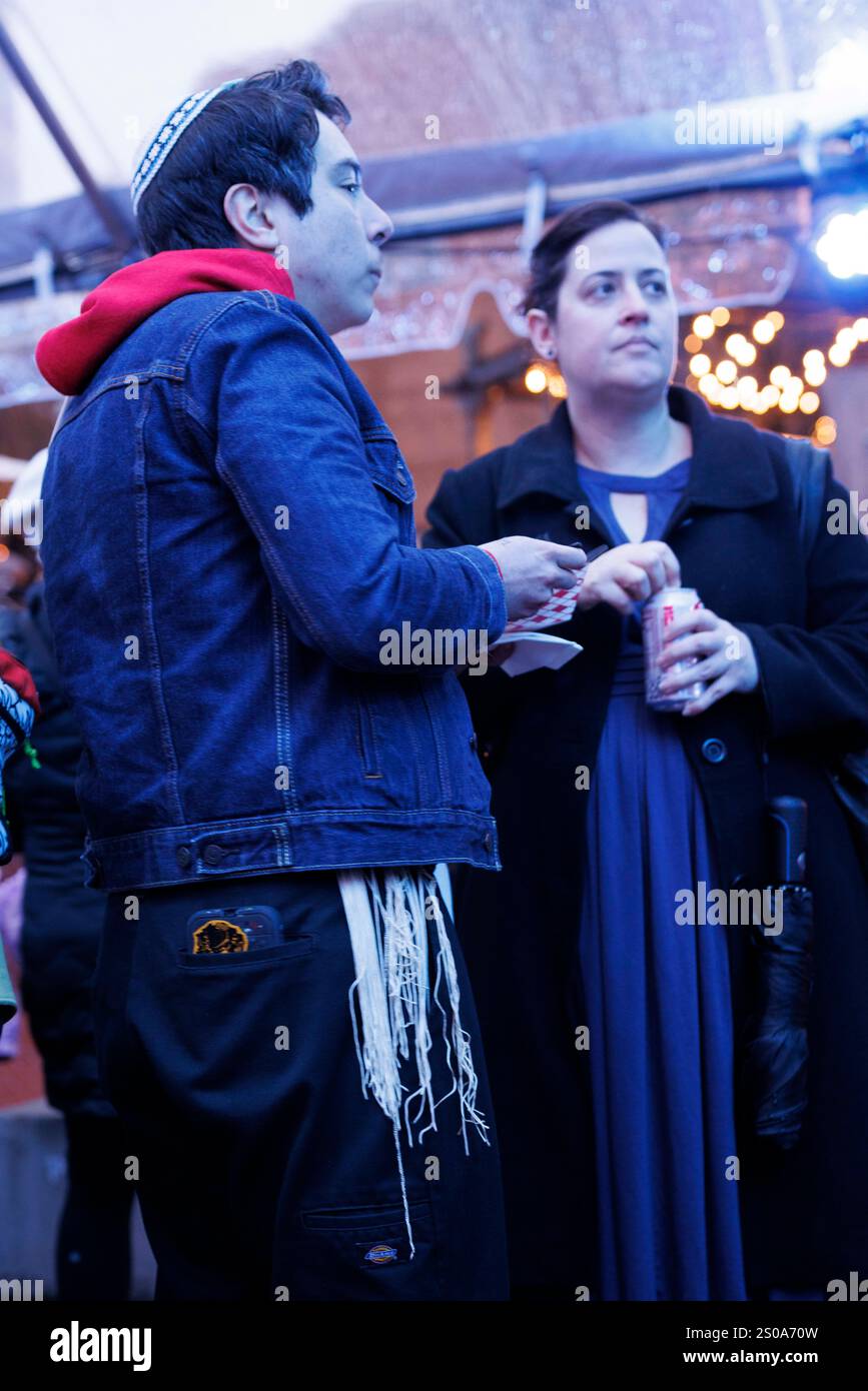 An observant Jewish man wears Tzitzit, while eating a latke. Hundreds ...