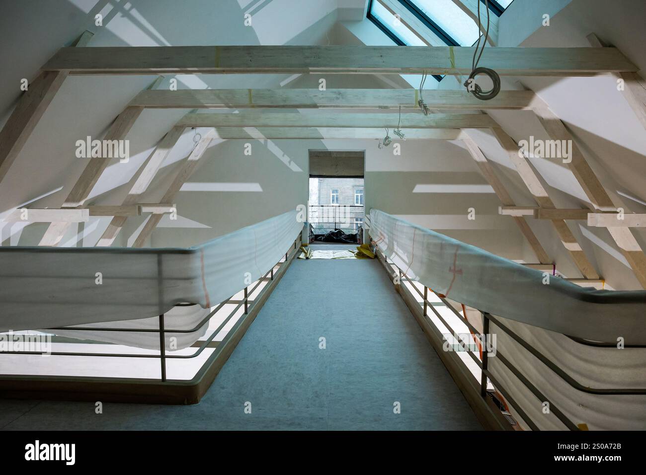 A narrow walkway under construction features protective railings ...
