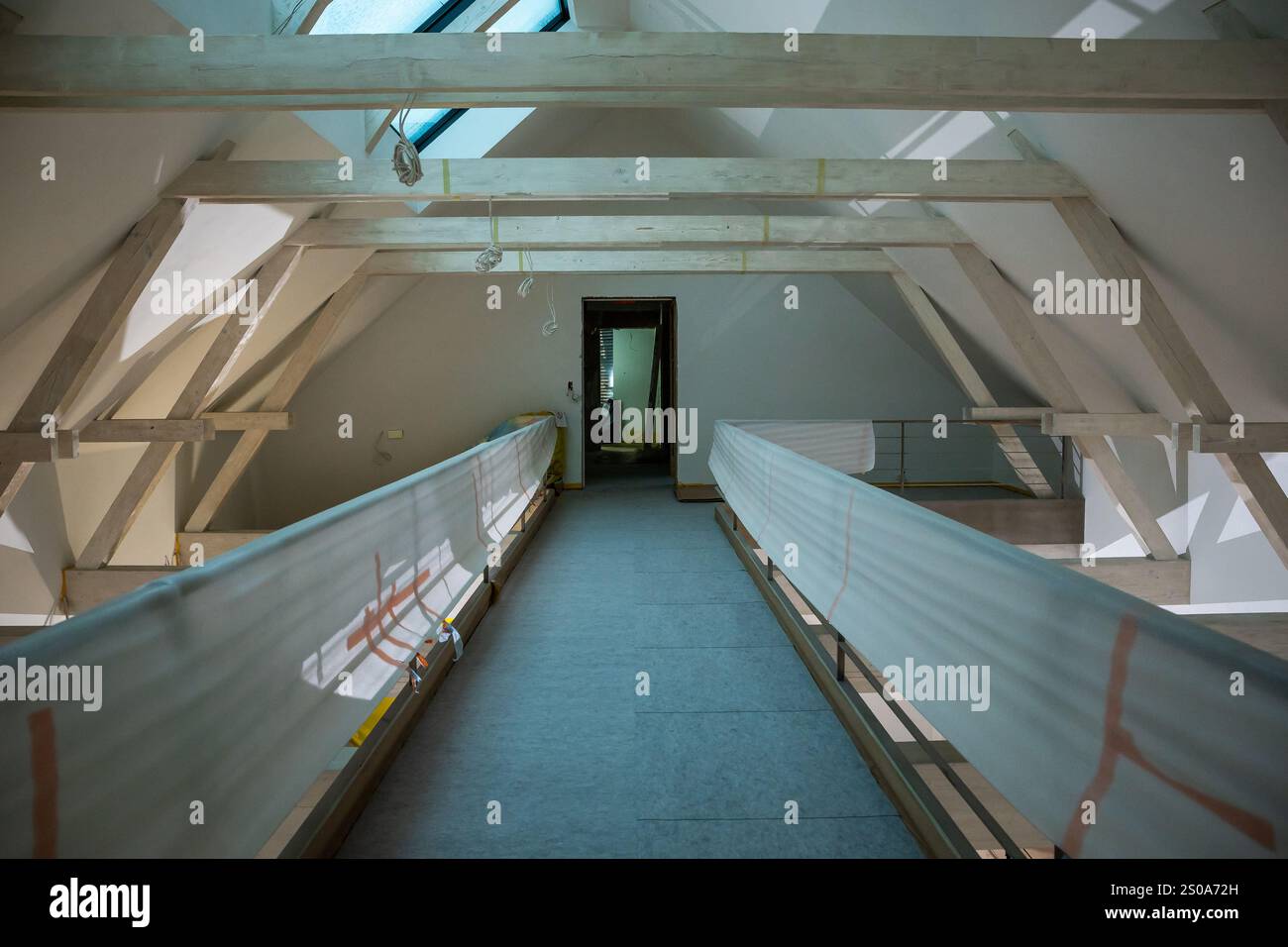 Interior view of an attic space featuring exposed wooden beams and a ...