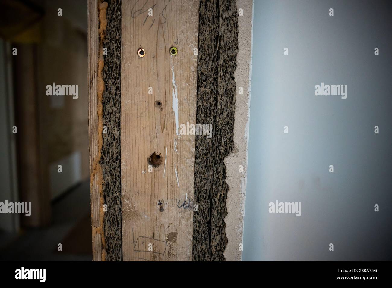 A detailed view of a wooden beam with screws and holes, resembling ...