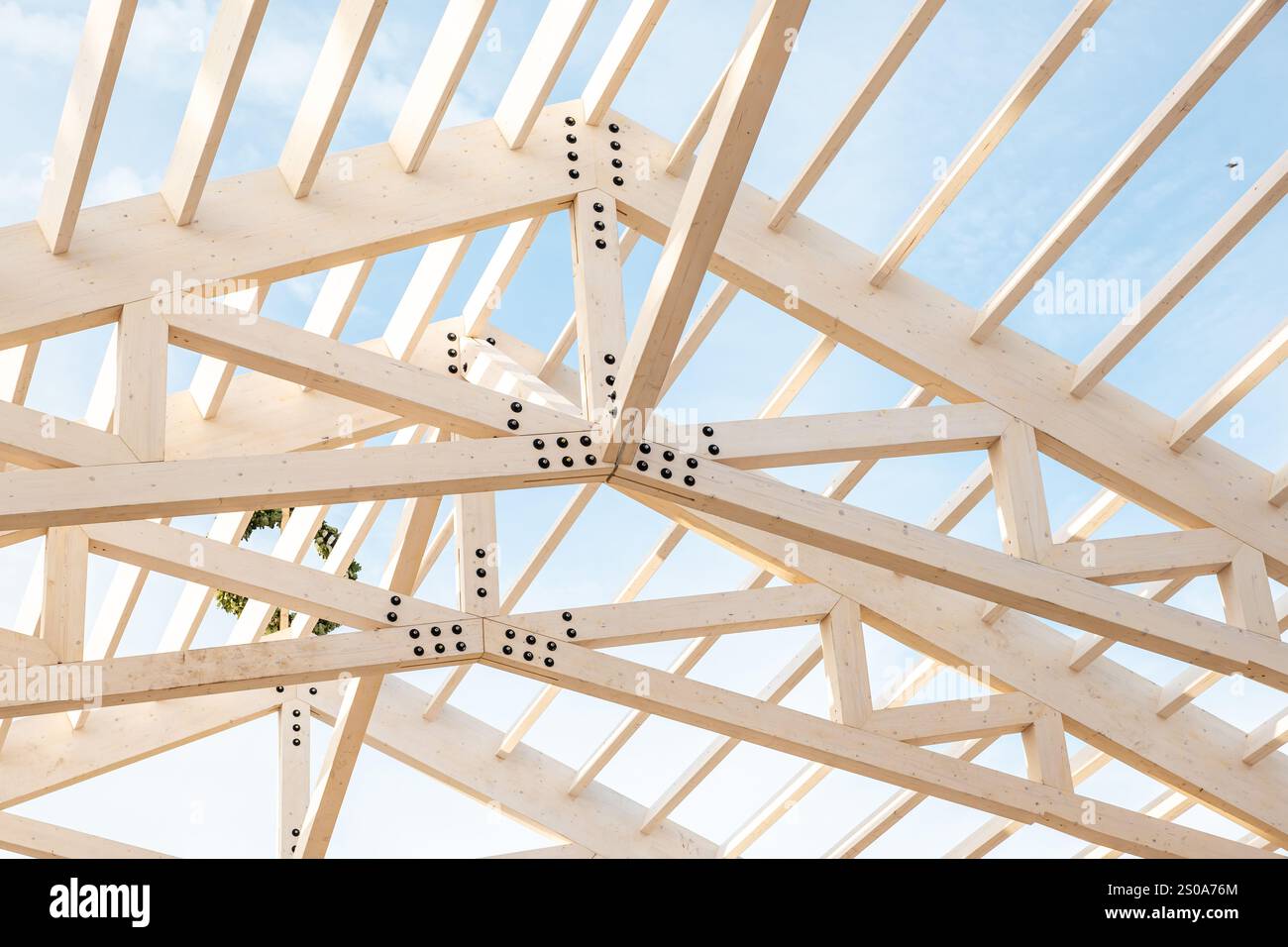 A detailed view of a wooden roof truss structure under construction ...