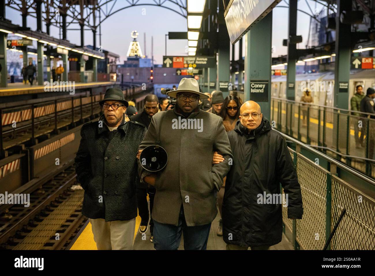 Rev. Kevin McCall, center, and community leaders walk through the F ...