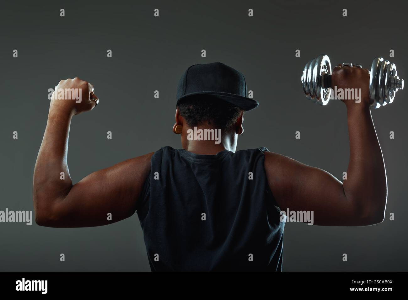 Athletic black woman in a backwards baseball cap and black tank top ...