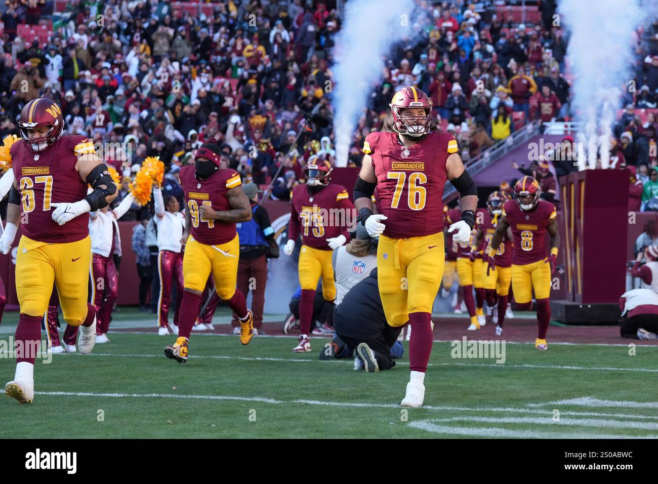Washington Commanders guard Sam Cosmi (76) and the Commanders team take ...
