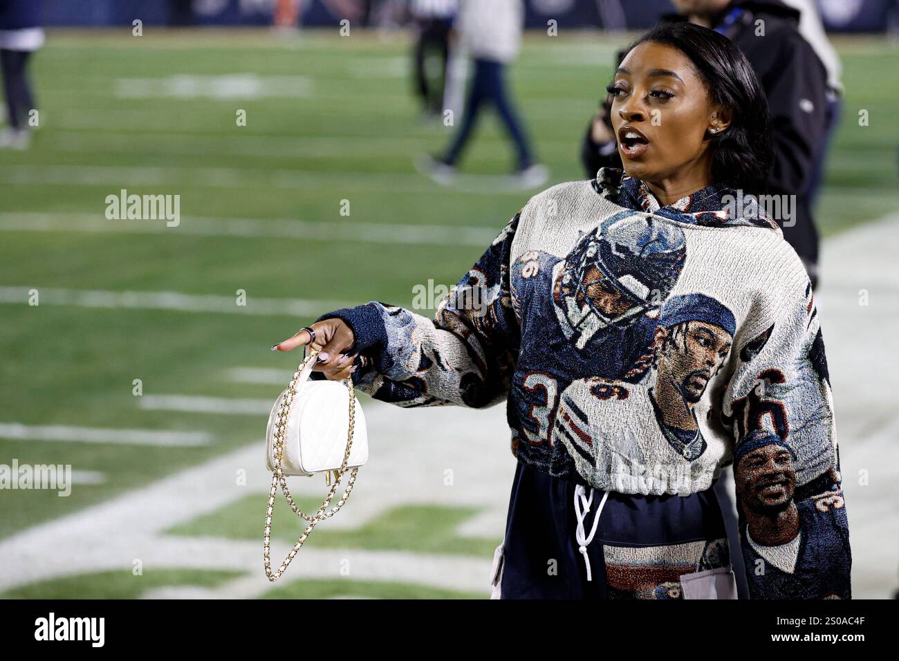 Simone Biles stands on the sidelines before an NFL football game ...