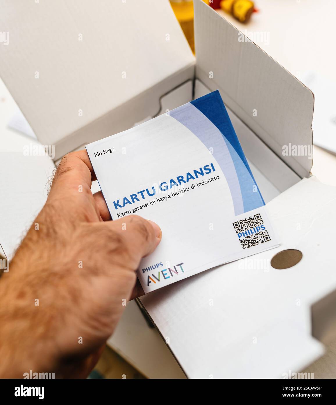Paris, France - Oct 25, 2023: A warranty card labeled Kartu Garansi inside the product box ...