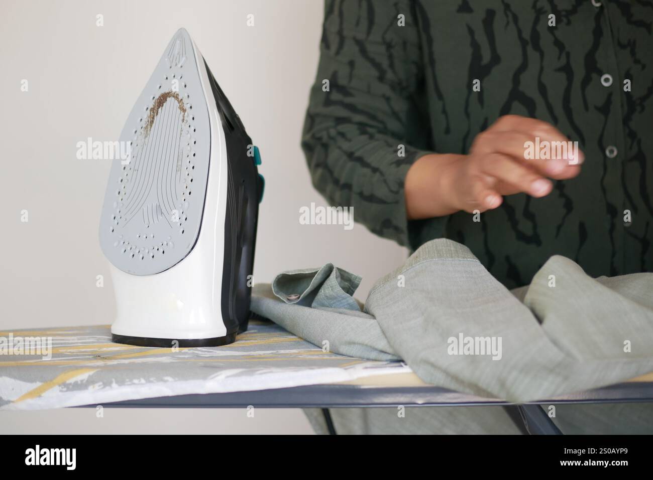 Ironing clothes with a steam iron on a board is key for neatness Stock ...