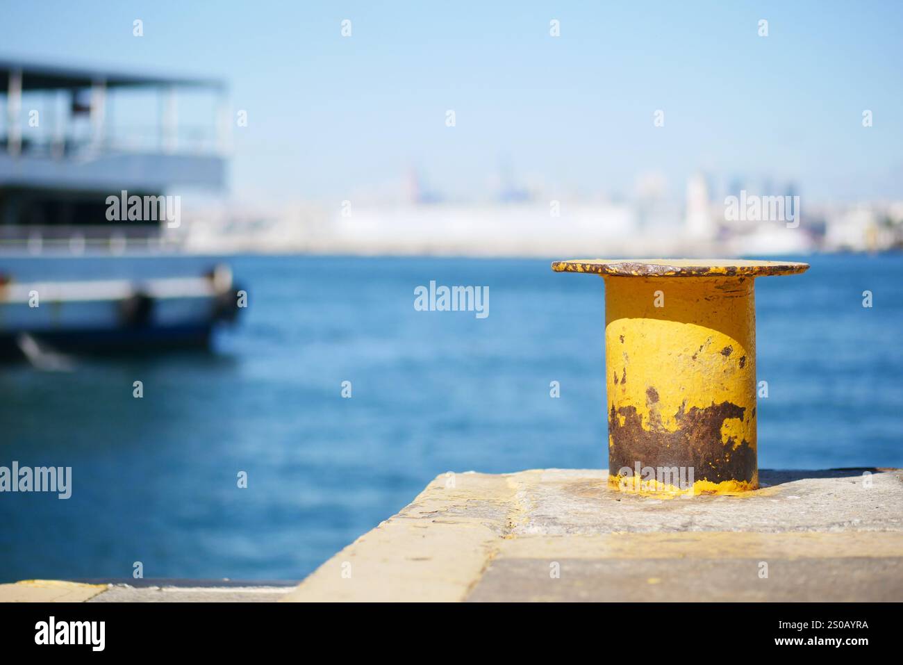 A striking Yellow Mooring Post stands proudly by the Waters Edge Stock ...
