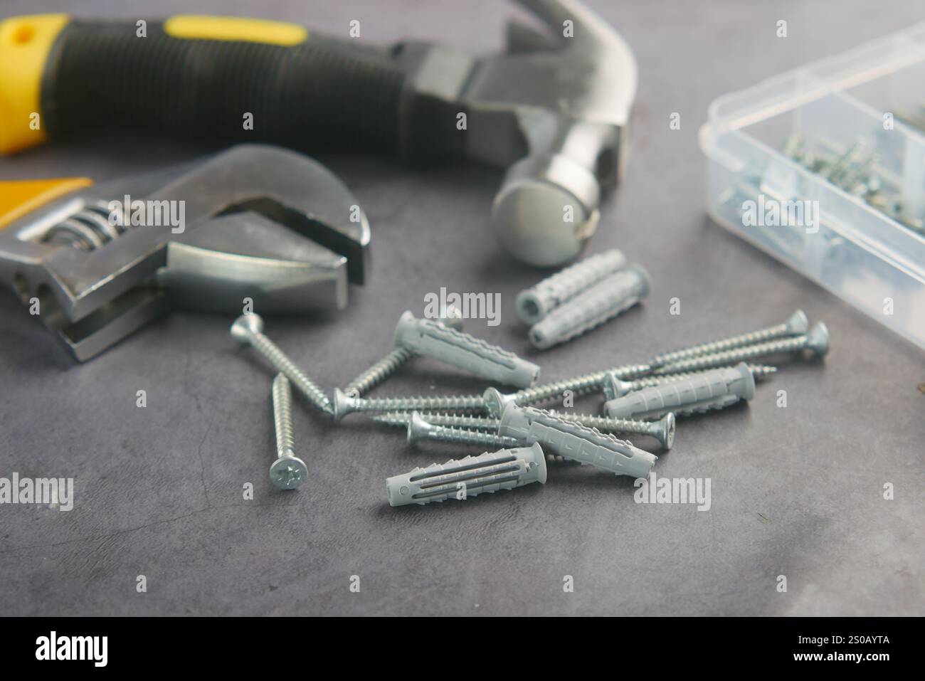 A collection of assorted hand tools and screws laid out on a work ...