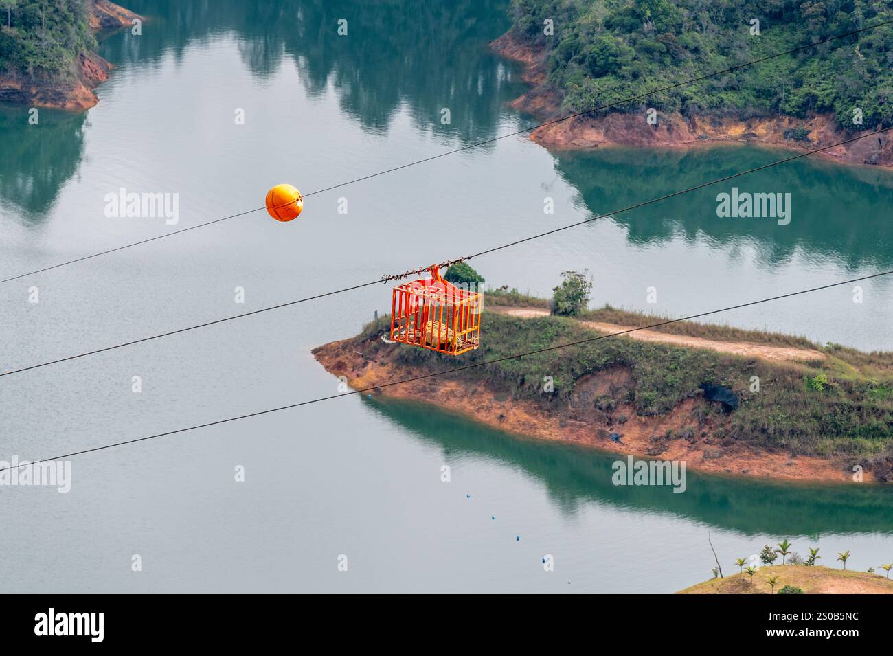 Aerial cable car ride over serene waters and lush landscapes. A ...