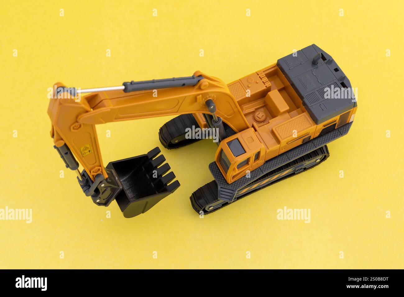 Miniature excavator scale model on yellow background. Top view Stock ...