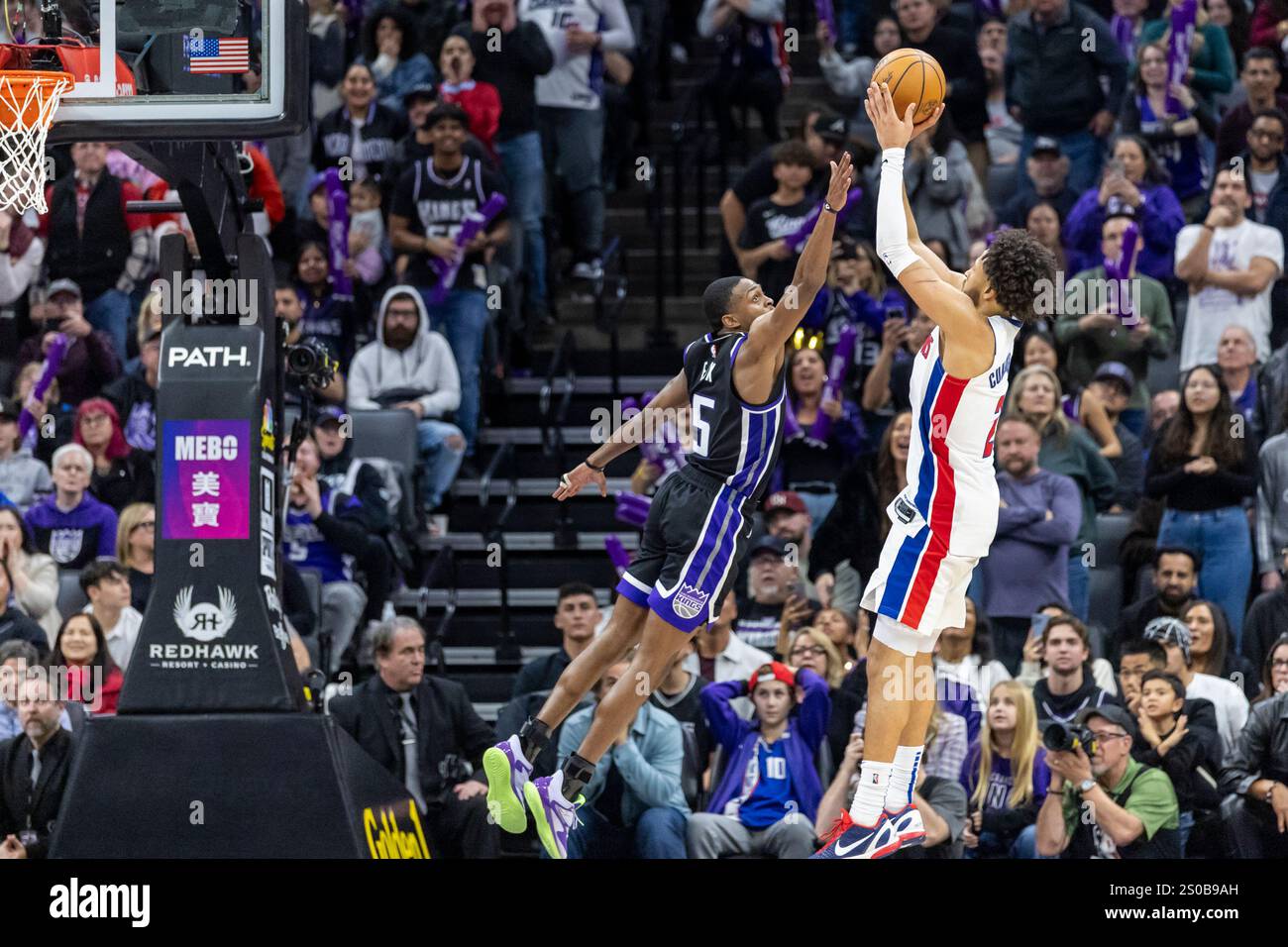 Detroit Pistons guard Cade Cunningham, right, attempts a jump shot over ...