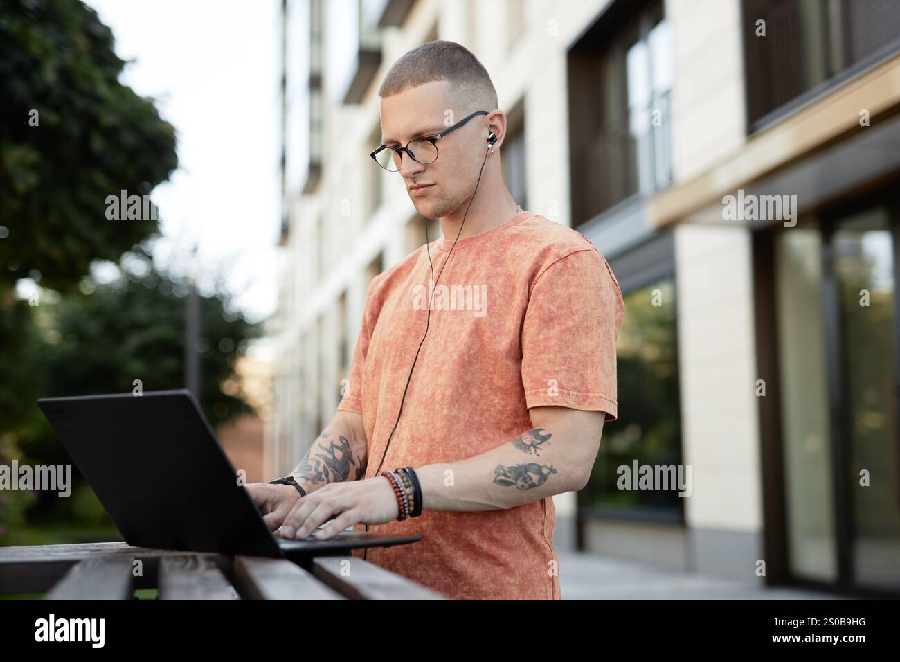 Medium shot of concentrated male IT programmer in wired headphones ...
