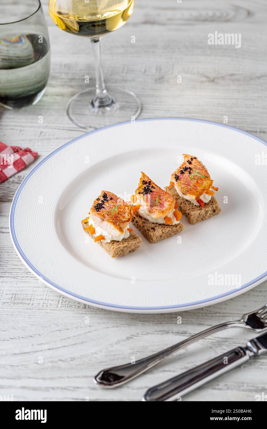 Red mullet with mash sauce on slices of bread in fine dining restaurant ...