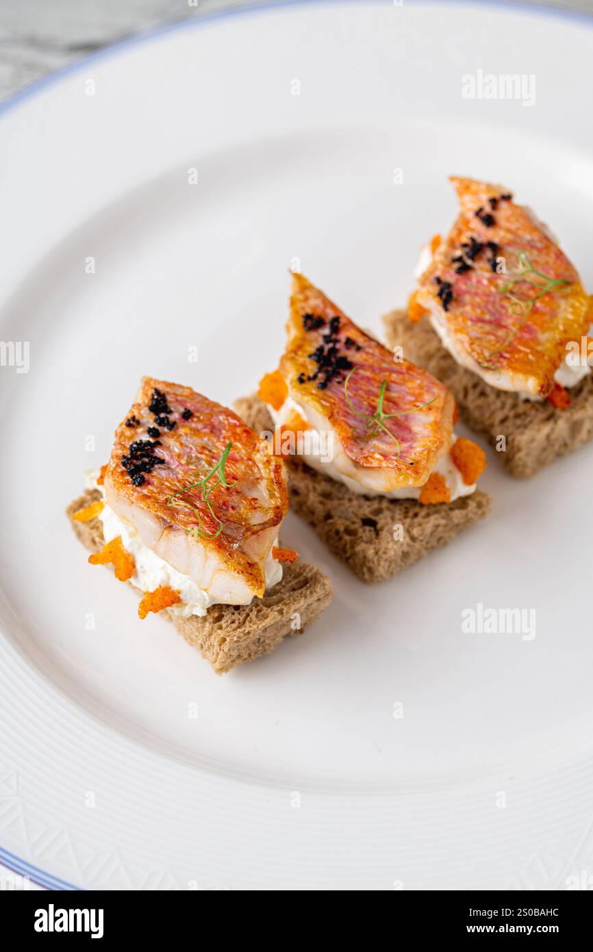Red mullet with mash sauce on slices of bread in fine dining restaurant ...