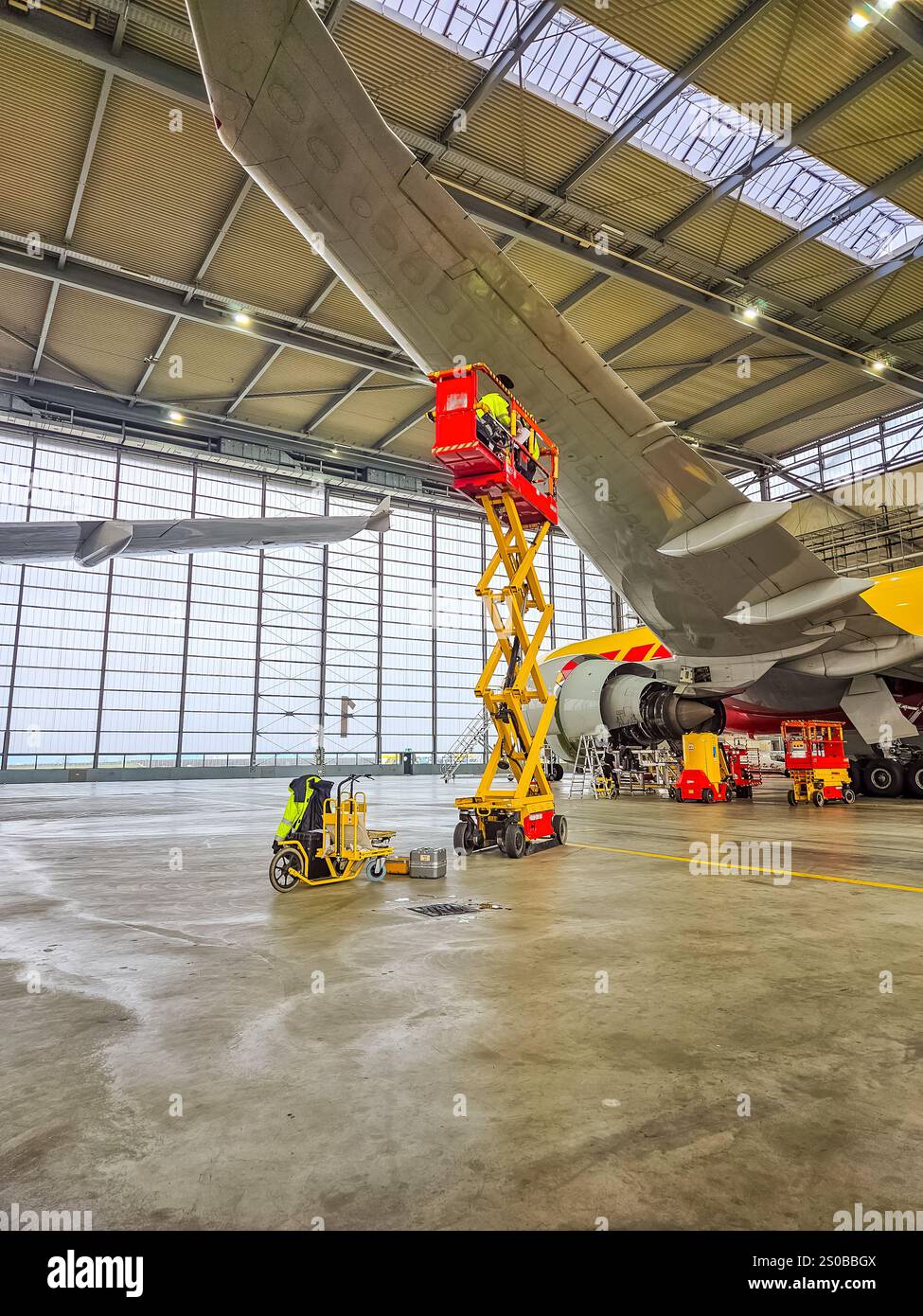 Technicians inspecting cargo plane in hangar. Aircraft maintenance crew ...