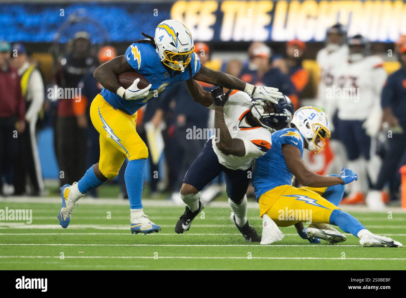 Los Angeles Chargers running back Gus Edwards (4) stiff arms Denver ...