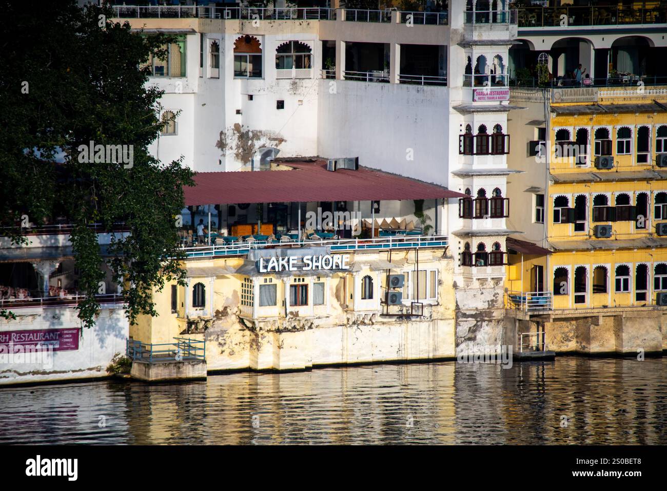 Old traditional stone buildings houses, resturants on the banks of lake ...