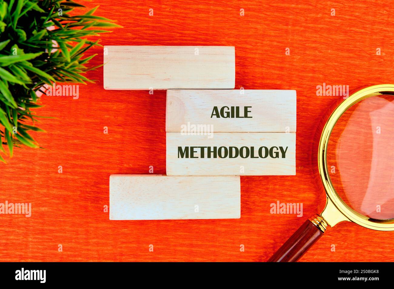 On a bright orange background, wooden blocks display the words agile ...