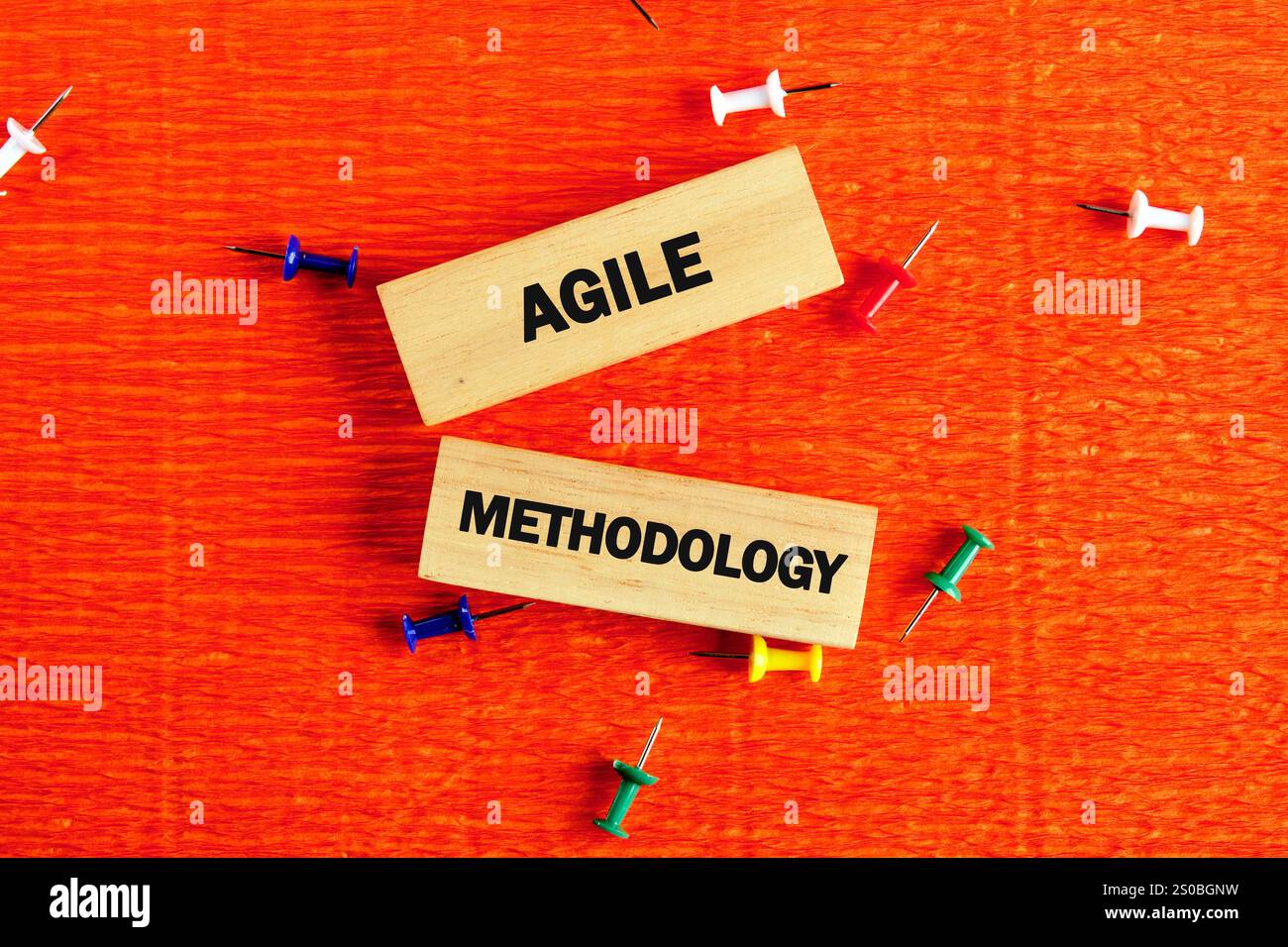 Two wooden blocks display the words agile and methodology, surrounded ...