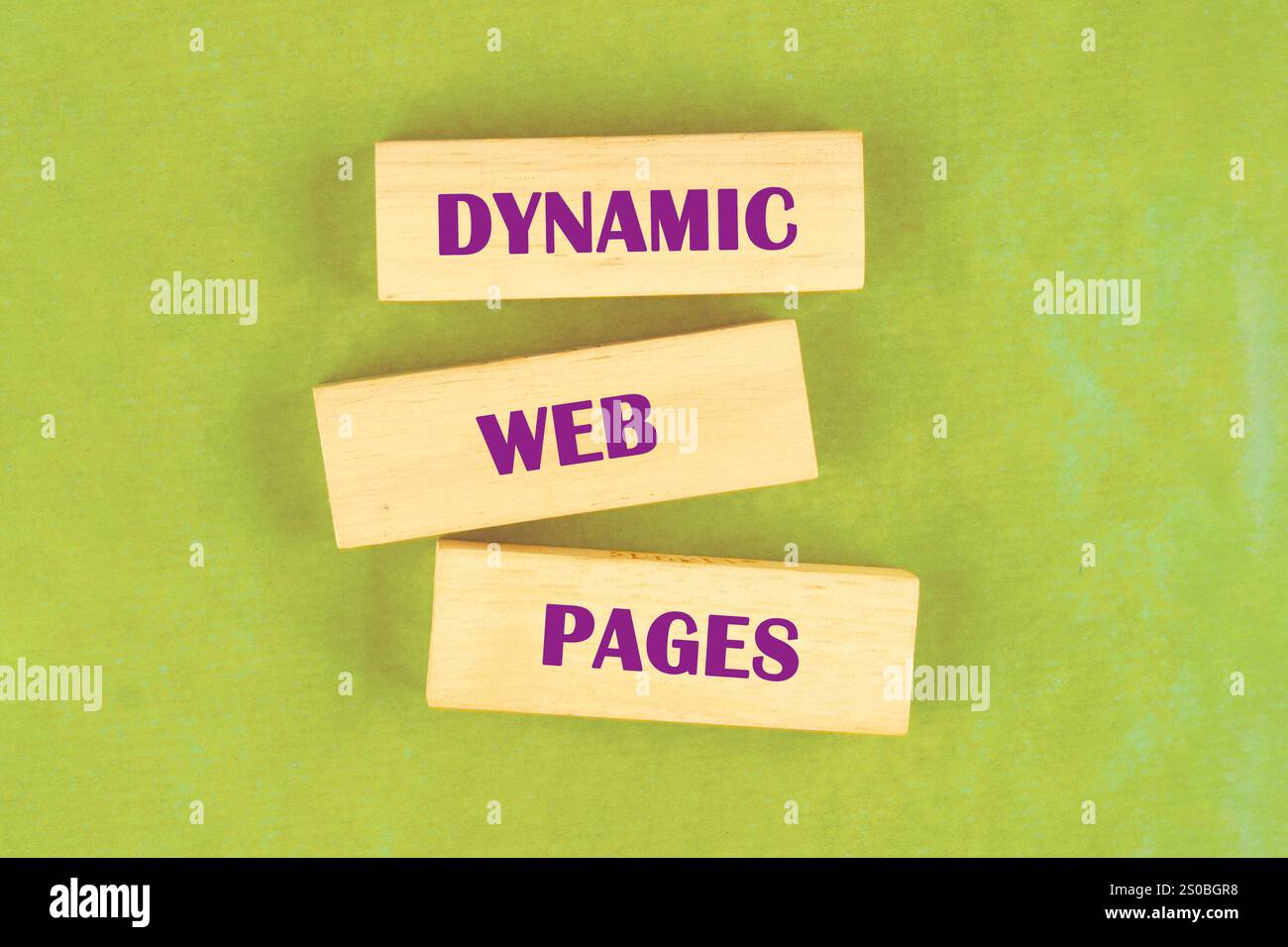 Wooden blocks display the words dynamic web pages against a green ...