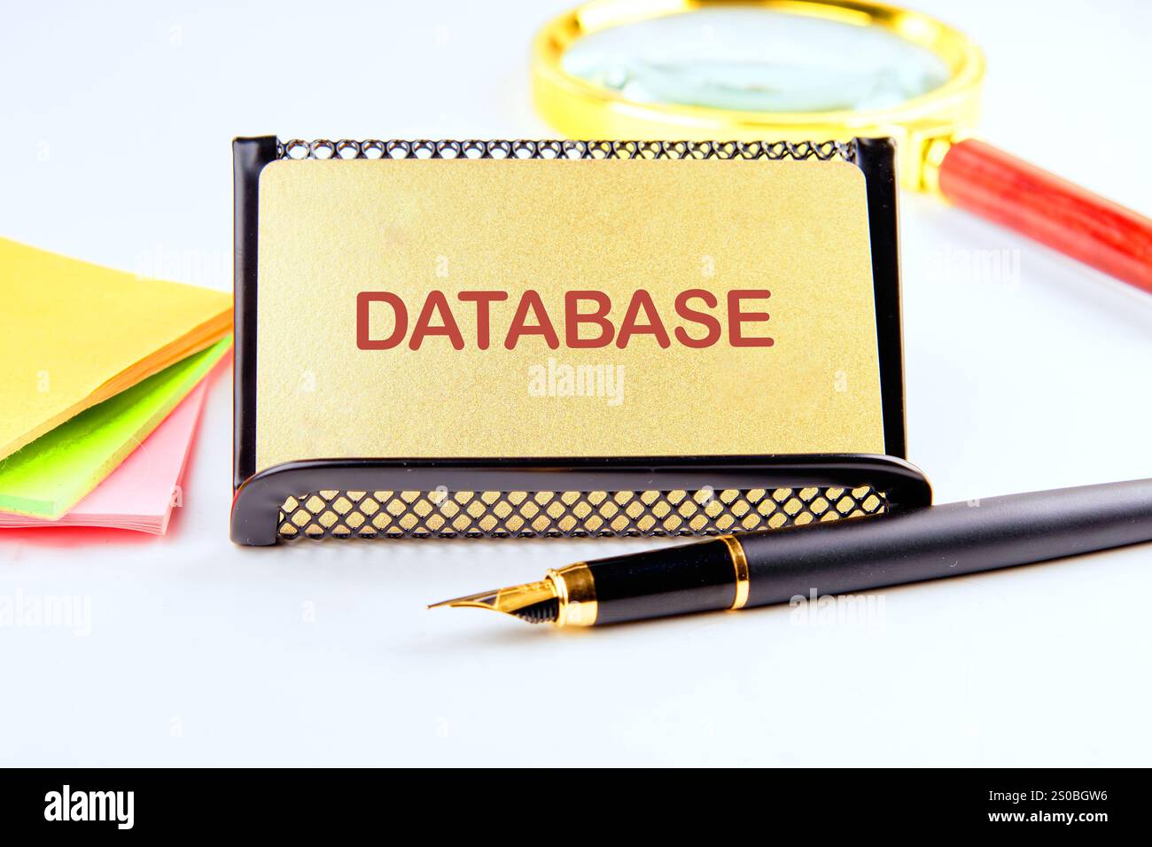 A golden card labeled DATABASE sits on a desk alongside colorful sticky ...