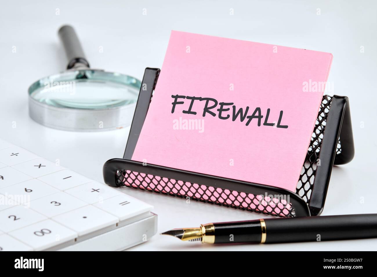 A pink note labeled FIREWALL sits in a black desk organizer beside a ...
