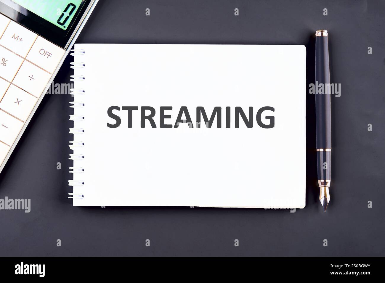 A notepad with the word streaming written in bold letters sits next to ...