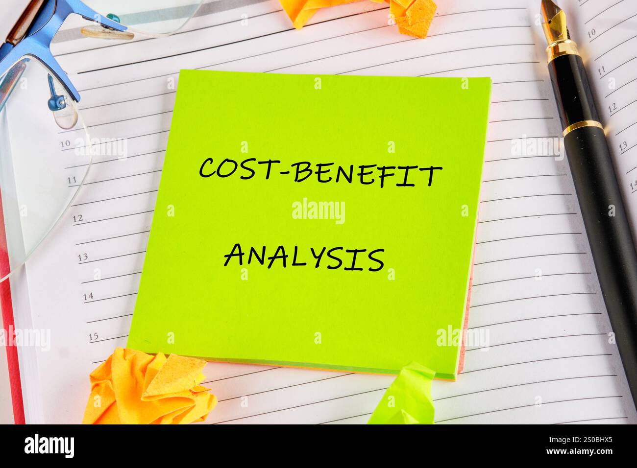 A bright green sticky note displaying the phrase cost-benefit analysis ...