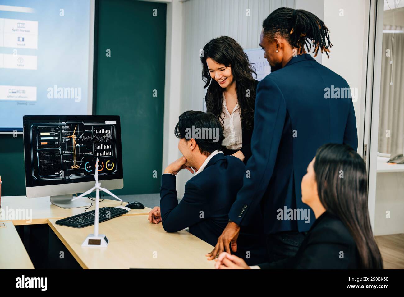 A diverse group of coworkers meeting around a desktop computer ...