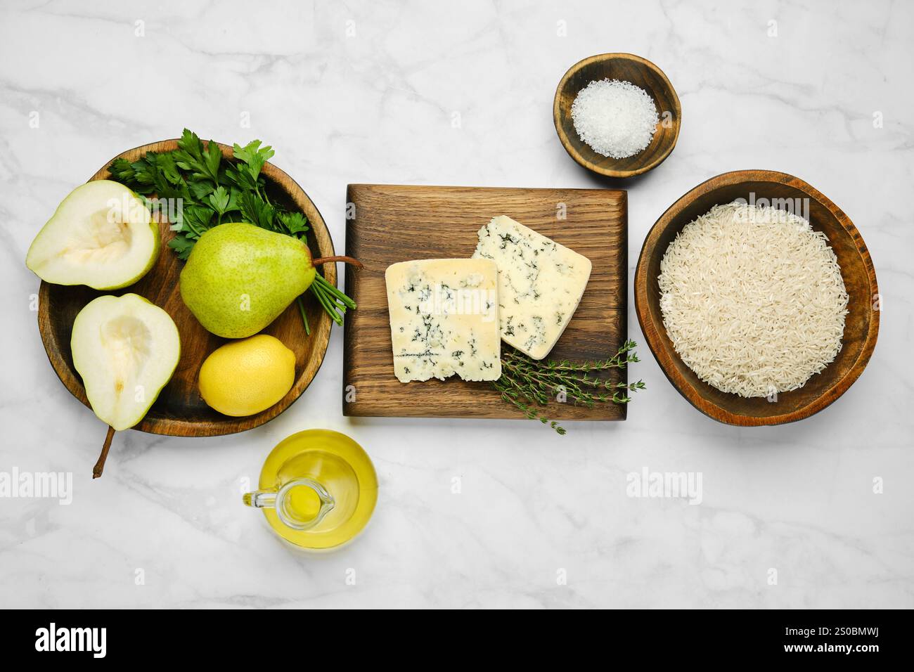 Overhead view of sliced pear, lemon, and parsley are alongside bowls of ...