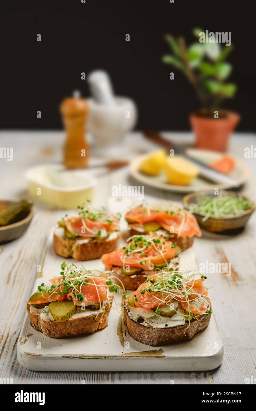 Freshly prepared open-faced sandwiches with smoked salmon, pickles, and ...