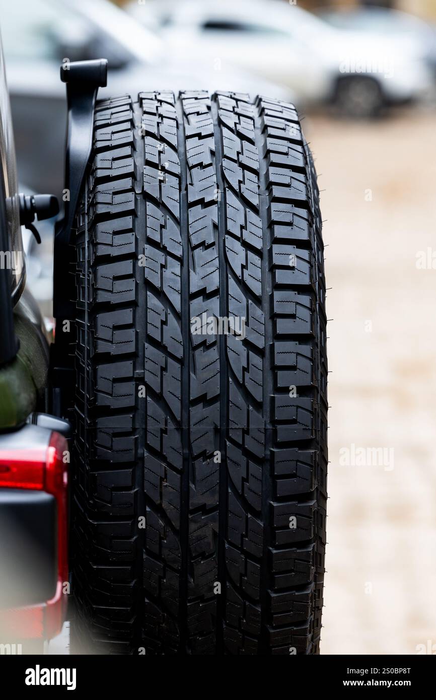 Deep tread of a new off road tire mounted on the rear door of an off ...