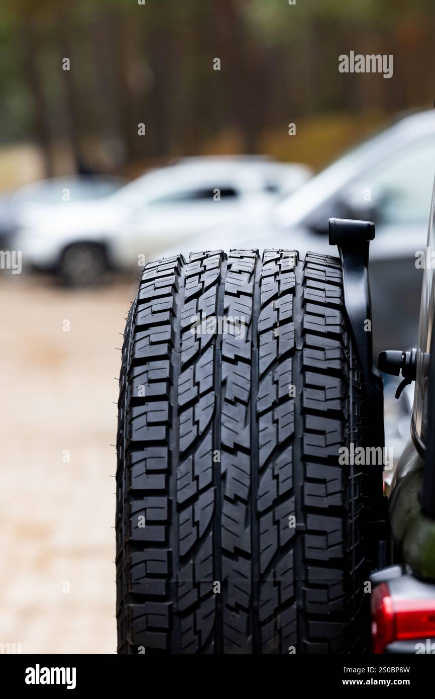 Deep tread of a new off road tire mounted on the rear door of an off ...