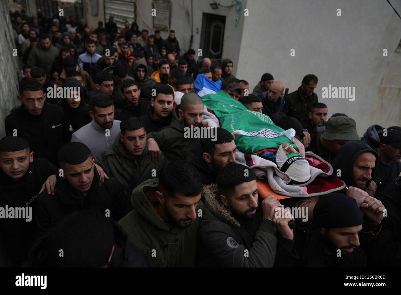 Mourners carry the body of Palestinian Zein Atatrah, 18, wrapped with a ...